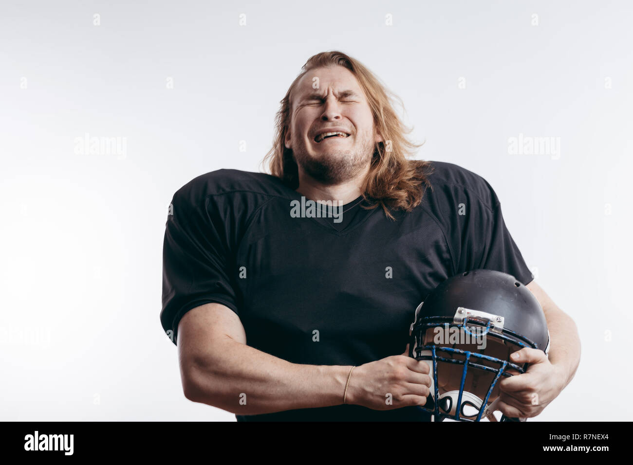 Rugby football player in despair, man with long hair over isolated ...