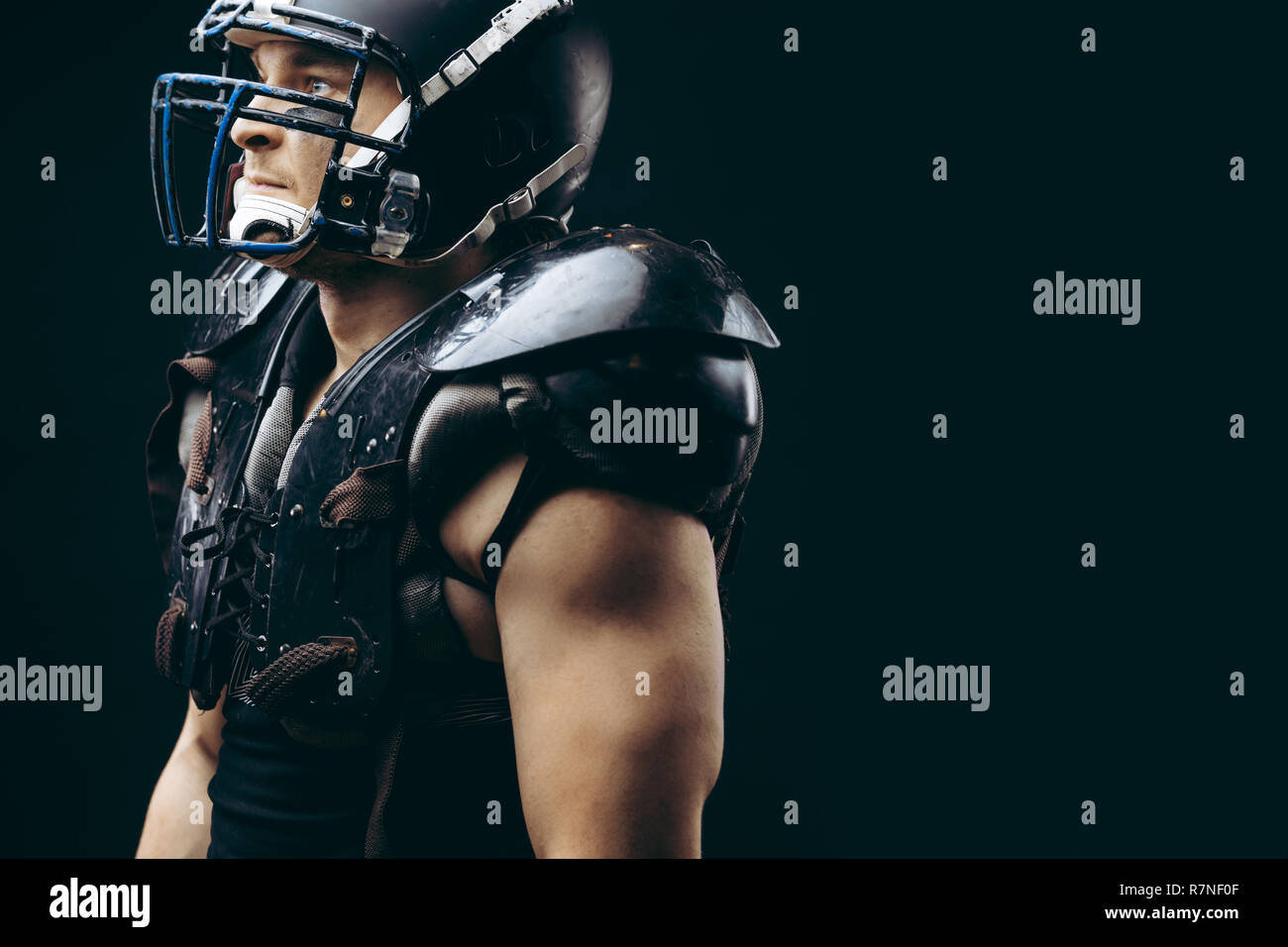 American football player with ball wearing helmet and protective ...