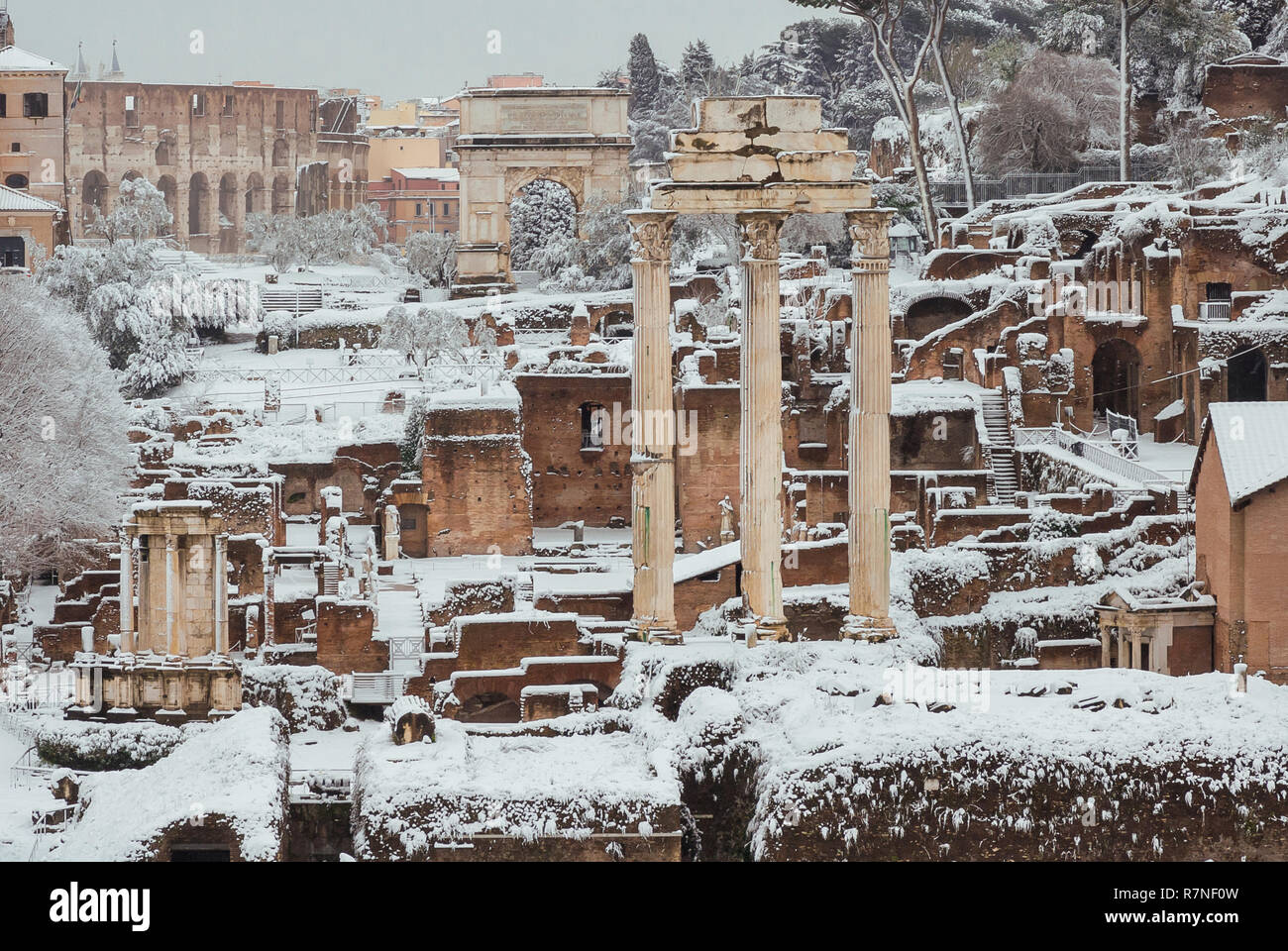 Frozen Rome. View of Roman Forum ancient ruins and Coliseum covered by ...