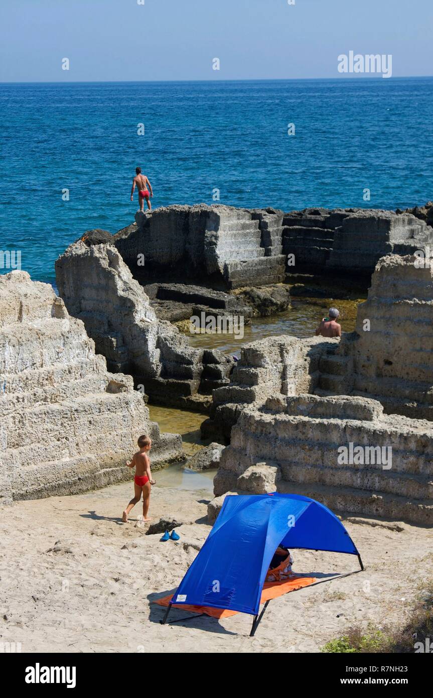 Italy, Puglia, Gallipoli, Tourists on the beach, in the middle of Roman ...