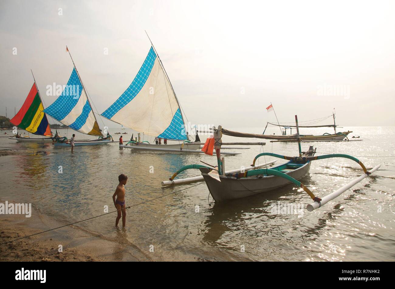 Indonesia, Java, Pasir Putih, Boy on the beach in front of traditional ...