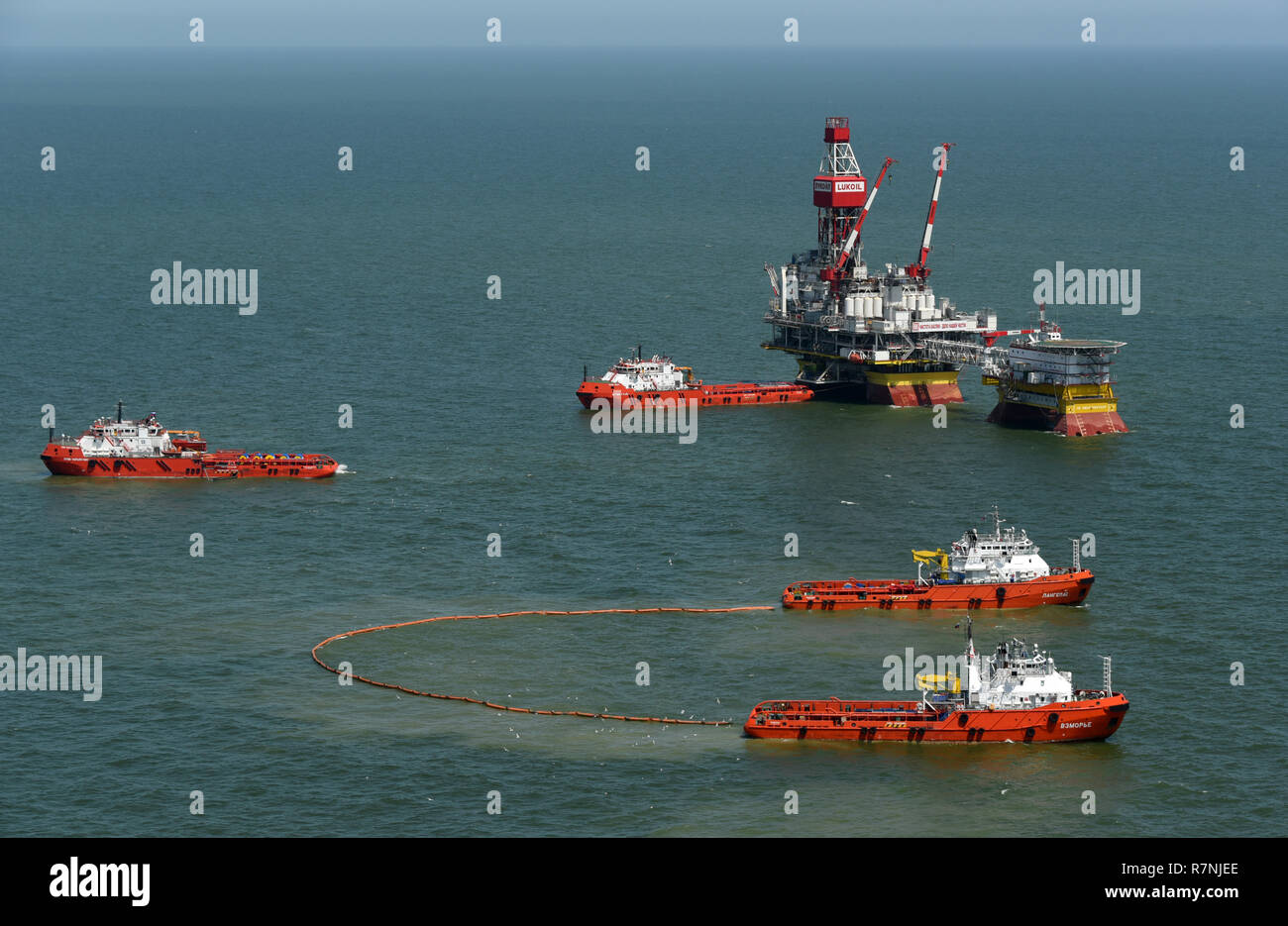 Rescue ships deploy a marine boom during the fire fighting training ...