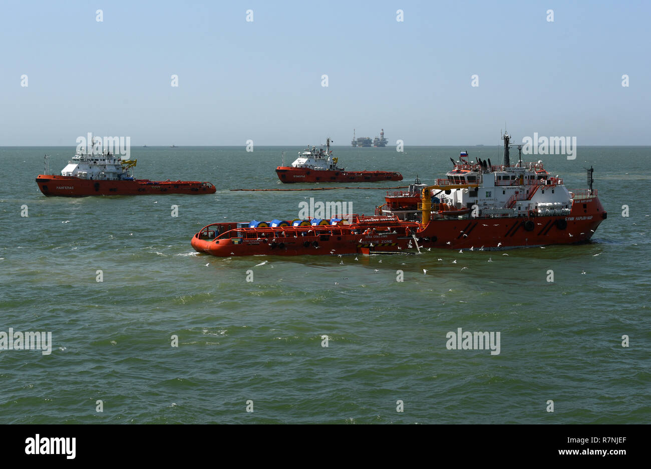 Rescue ships deploy a marine boom during the fire fighting training ...