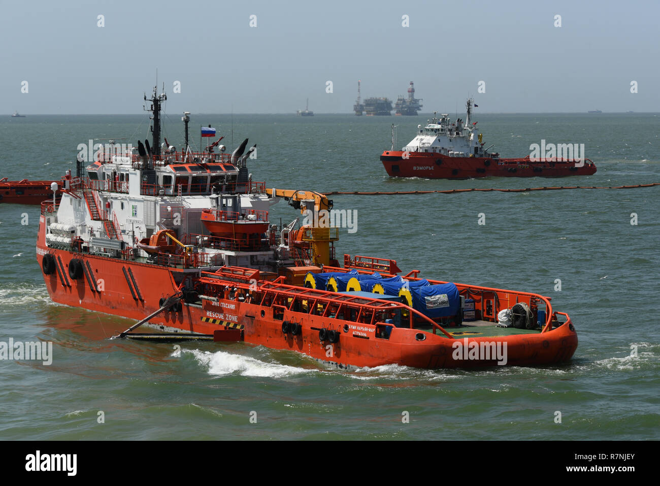 Rescue ships deploy a marine boom during the fire fighting training ...