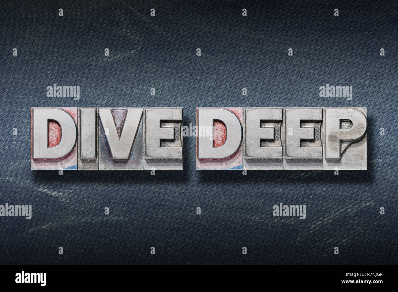 dive deep phrase made from metallic letterpress on dark jeans ...