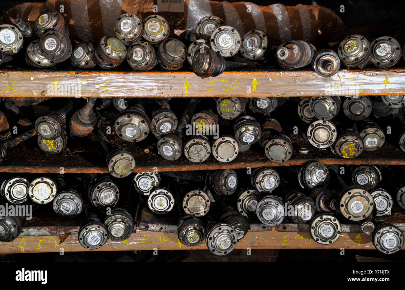 Car parts stacked in a car breakers yard drive shafts Stock Photo Alamy