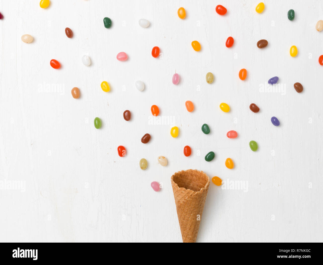 background with ice cream cone with many colorful jelly beans on white ...
