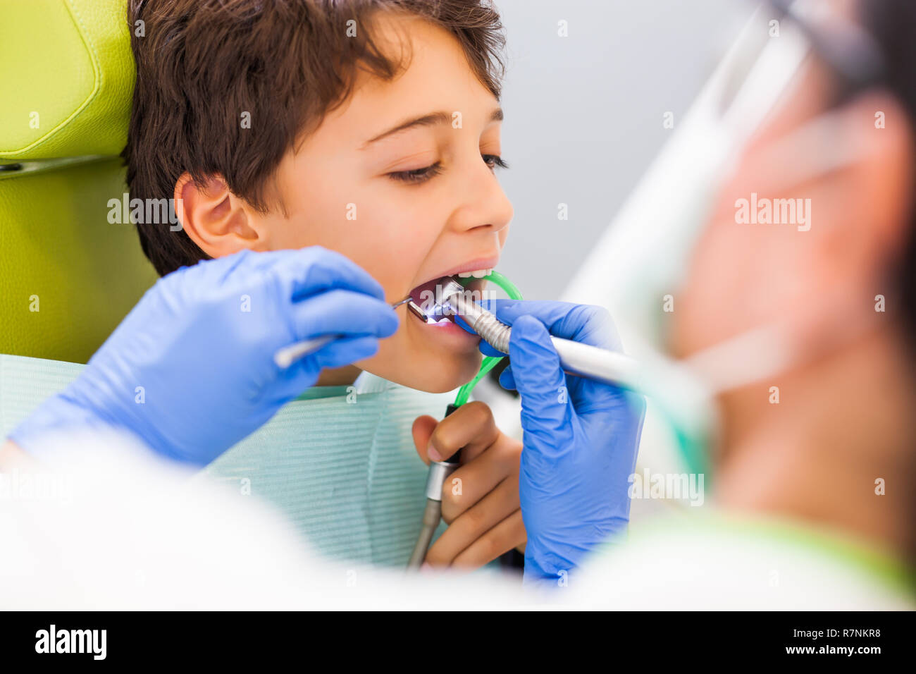 Dentist is repairing teeth of a little boy Stock Photo - Alamy
