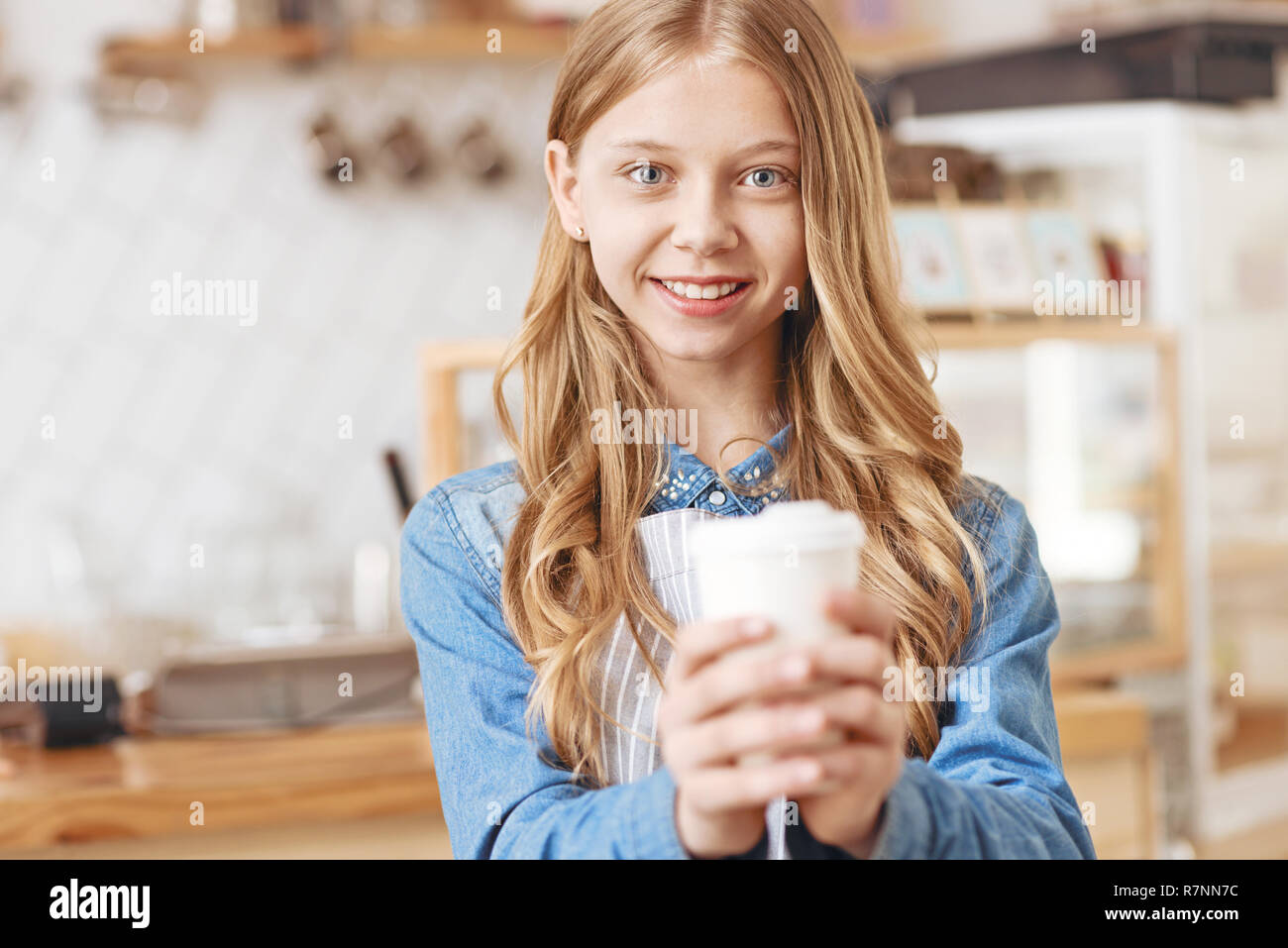 Mindful blonde girl treating guest to aromatic coffee Stock Photo - Alamy