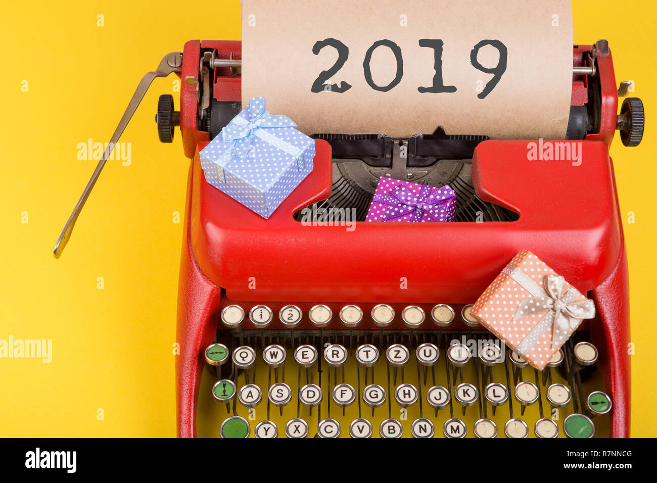 Holidays concept - red typewriter with text "2019", gift boxes on ...