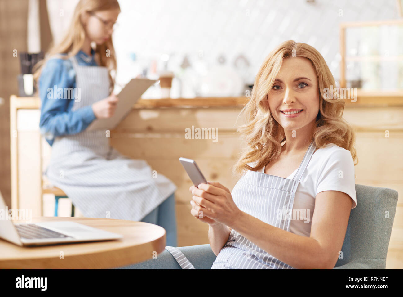 Calm smiling lady with phone looking into camera Stock Photo - Alamy