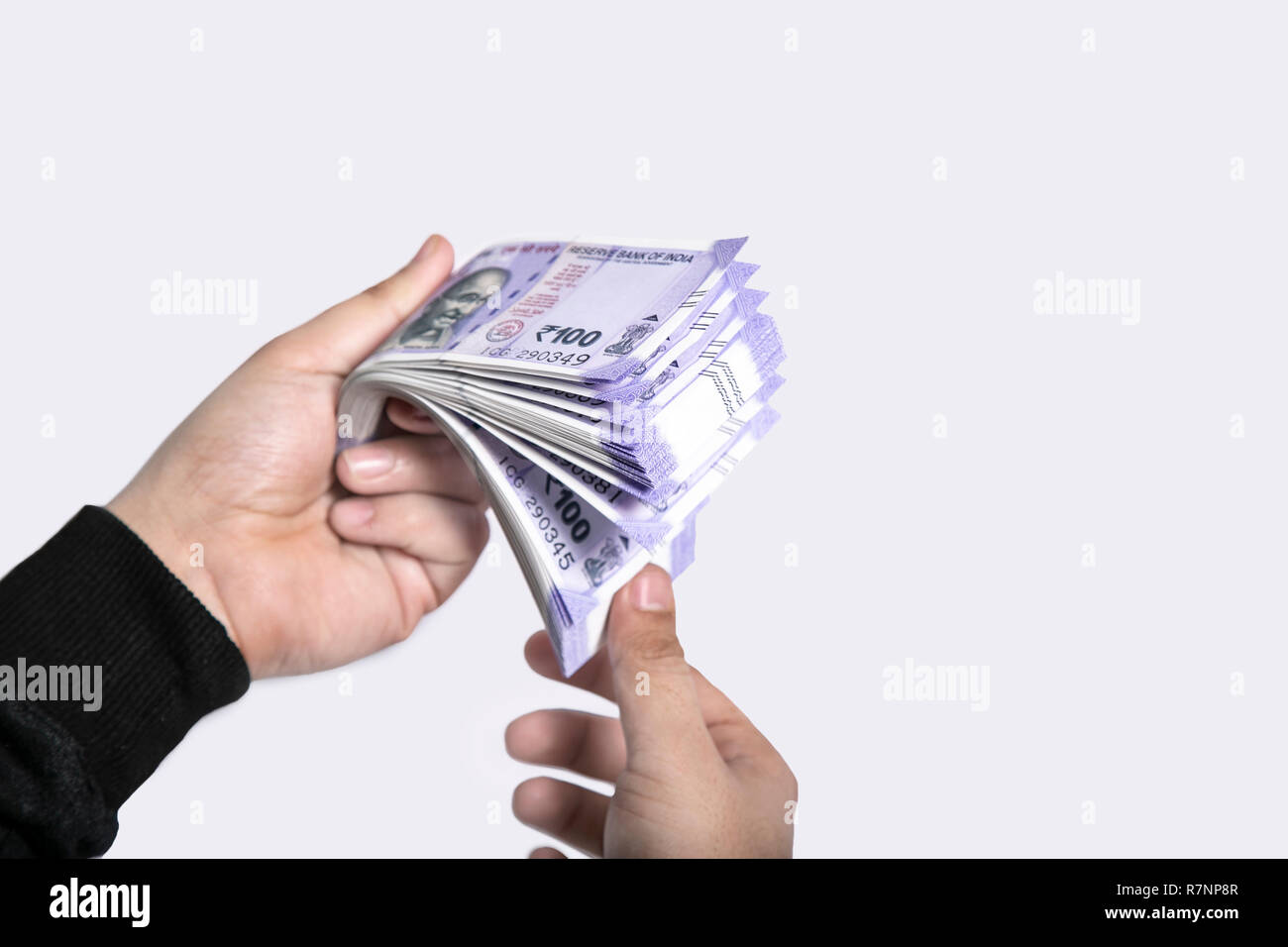 Hand with new Indian currency notes. Isolated on the white background ...