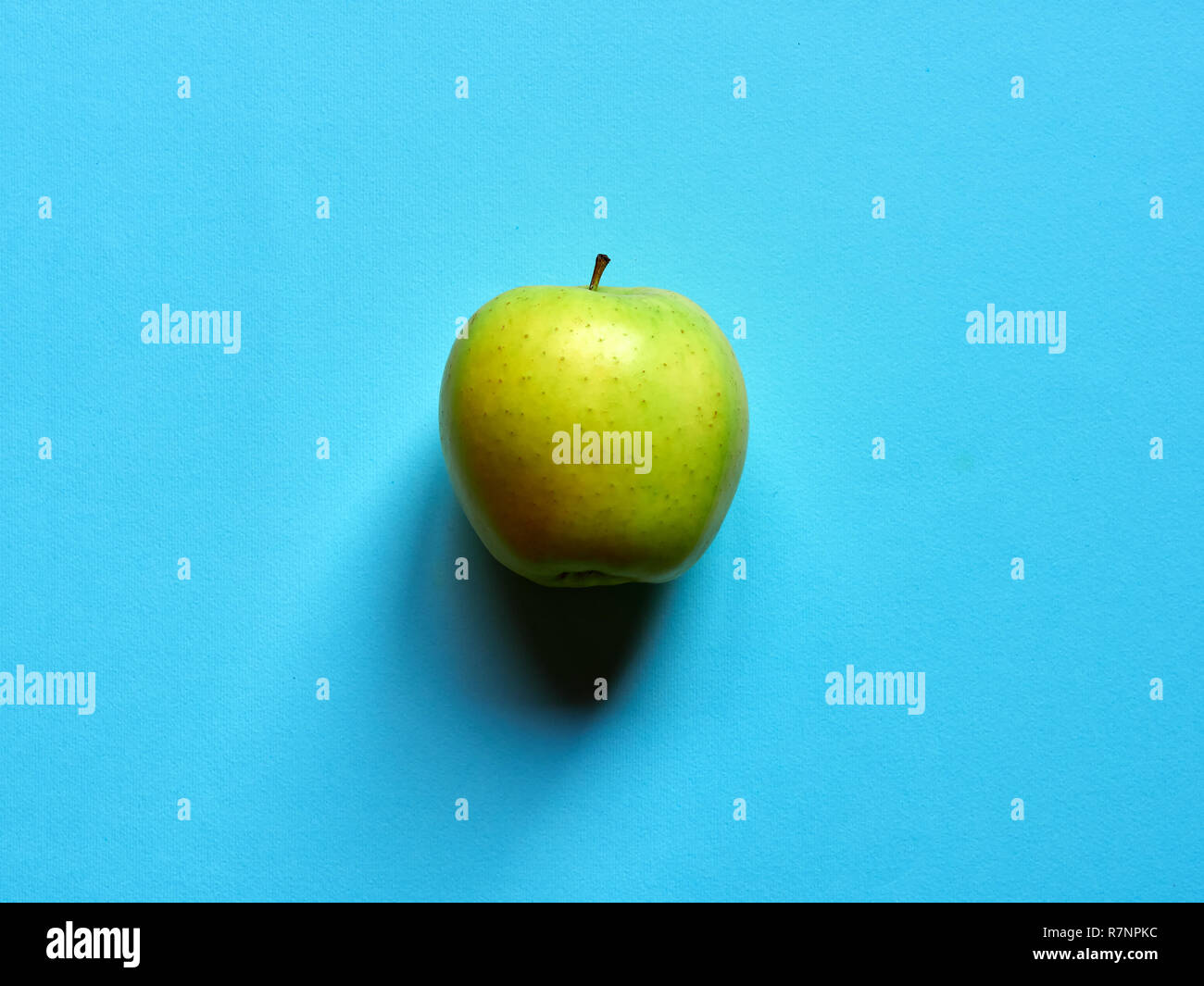 Single green apple isolated air frontal view in studio with a cyan ...