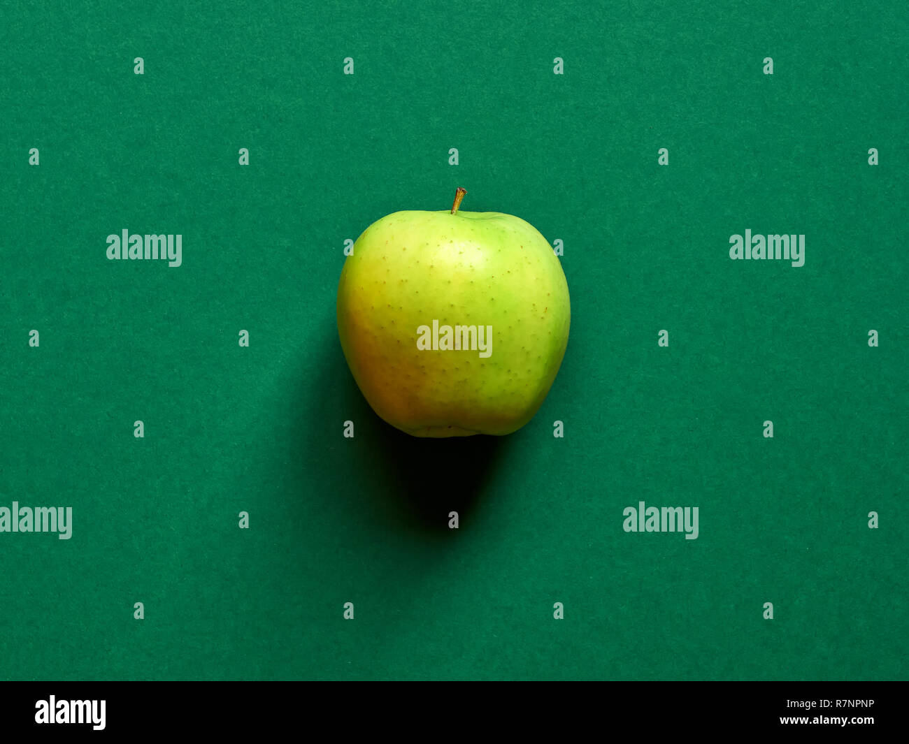 Single green apple isolated air frontal view in studio with a green ...