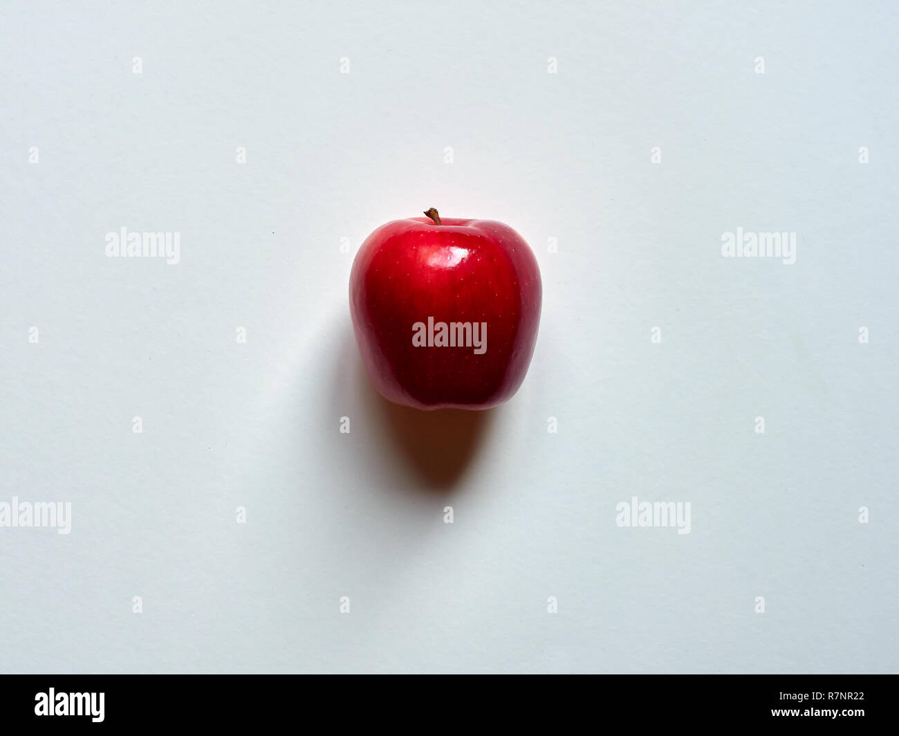 Single red apple isolated air frontal view in studio with a white ...