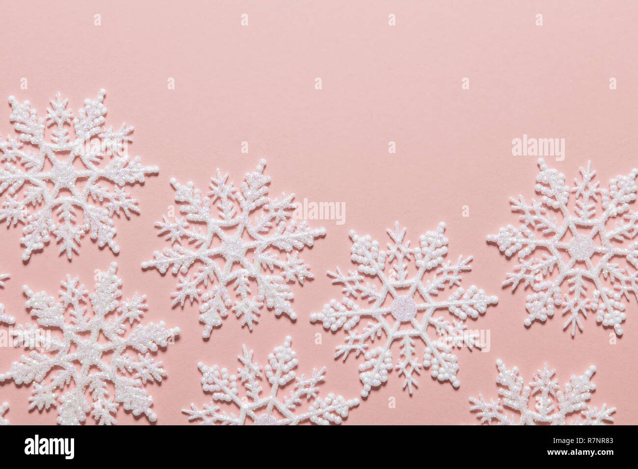 White glitter snowflake composition on a pastel pink background Stock ...