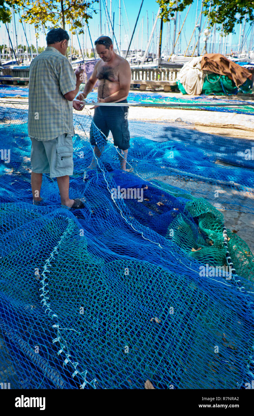 Fishing port men mending nets hi-res stock photography and images - Alamy