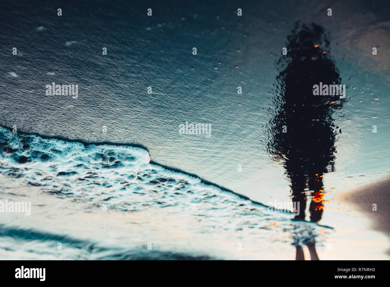 Reflection silhouette of a young woman at the sand beach Stock Photo ...