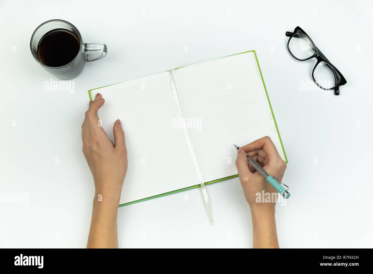 Creating new ideas concept. Top view of female hands writing in a copy ...