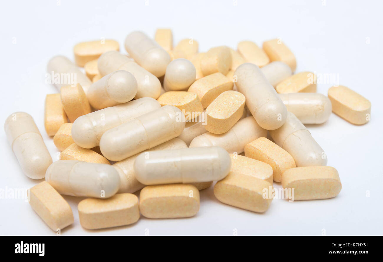 Medicine yellow pills or capsules on a white background close-up ...