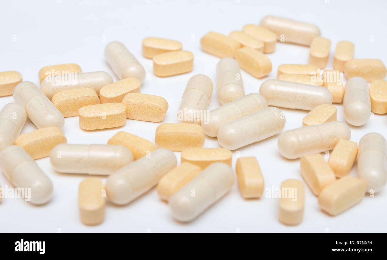 Medicine yellow pills or capsules on a white background close-up ...