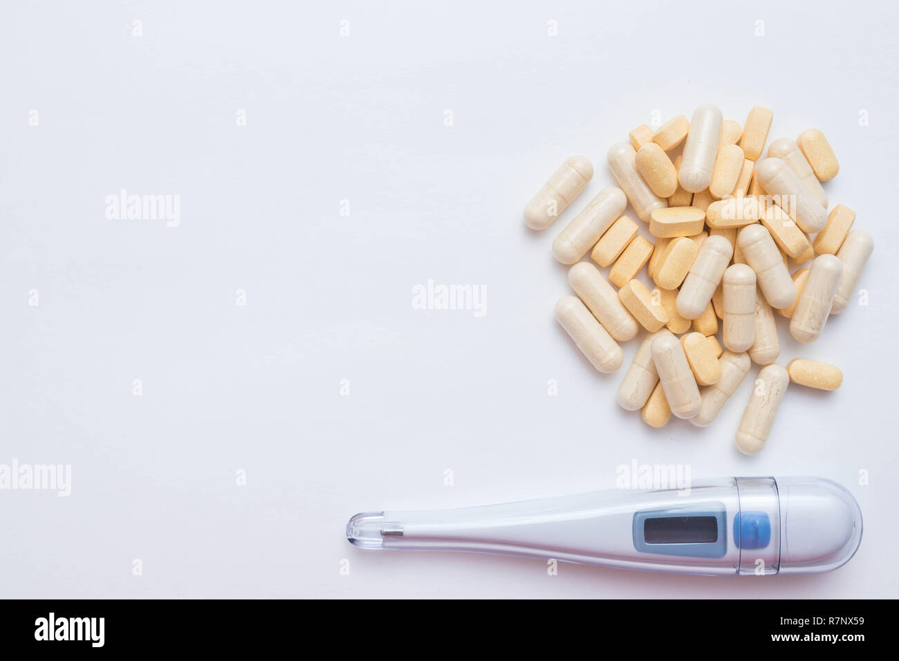 Medical thermometer, pills and capsules with the drug. Top view on ...