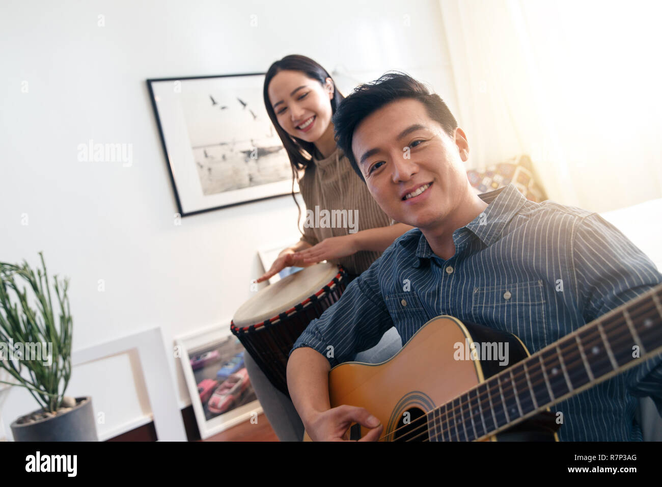 Happy couples playing Musical Instruments at home Stock Photo - Alamy