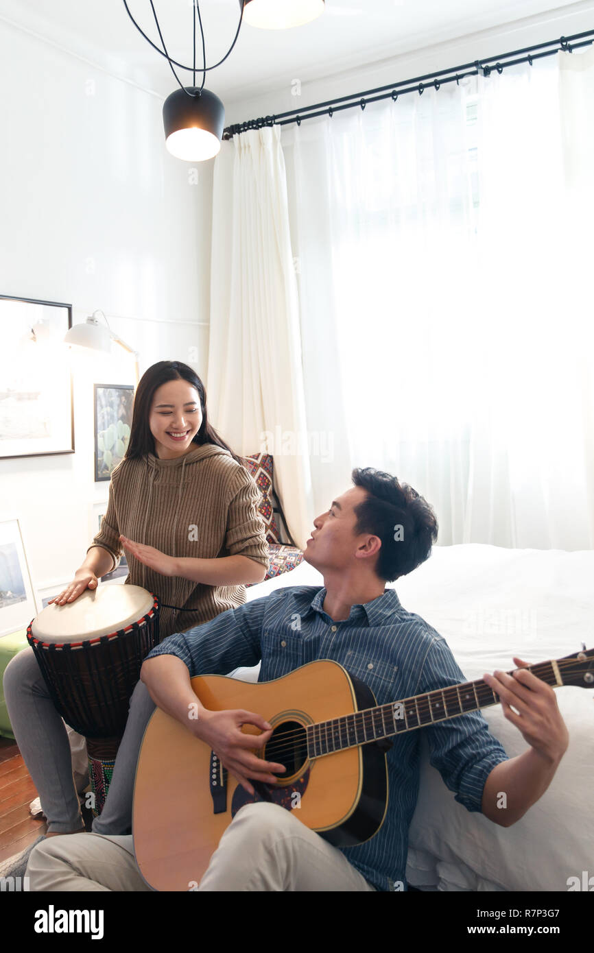 Happy couples playing Musical Instruments at home Stock Photo - Alamy