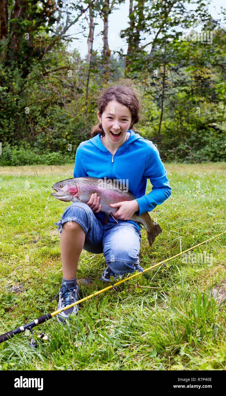 Teen girl holding large trout with big smile Stock Photo - Alamy