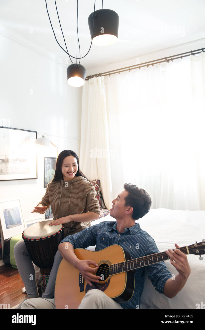 Happy couples playing Musical Instruments at home Stock Photo - Alamy