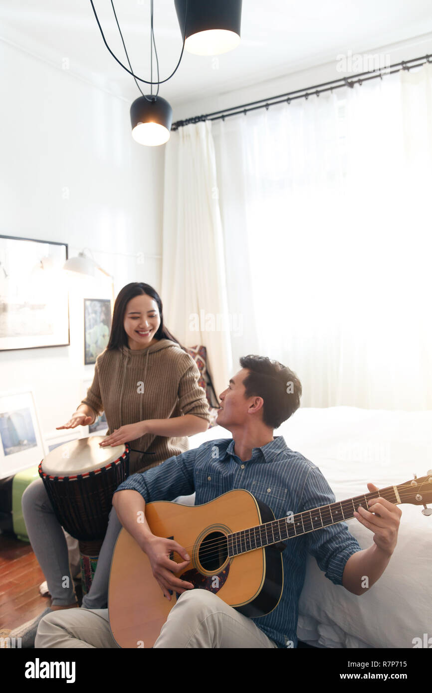 Happy couples playing Musical Instruments at home Stock Photo - Alamy