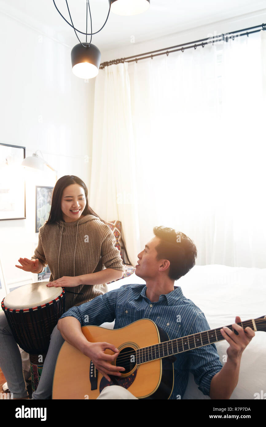 Happy couples playing Musical Instruments at home Stock Photo - Alamy
