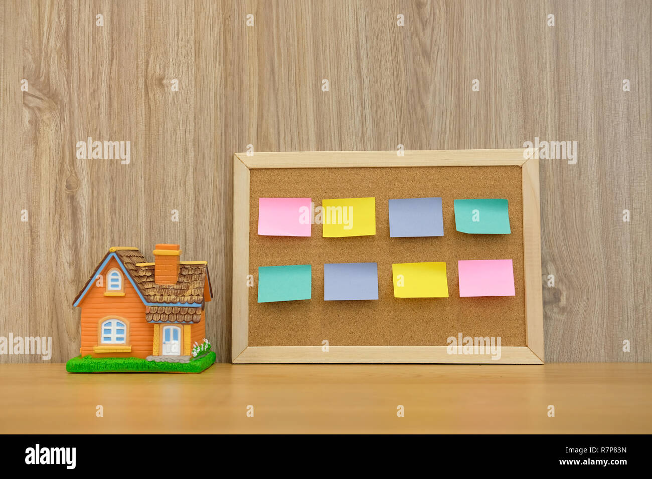 sticky notes paper reminder on cork board & house model on wooden desk ...