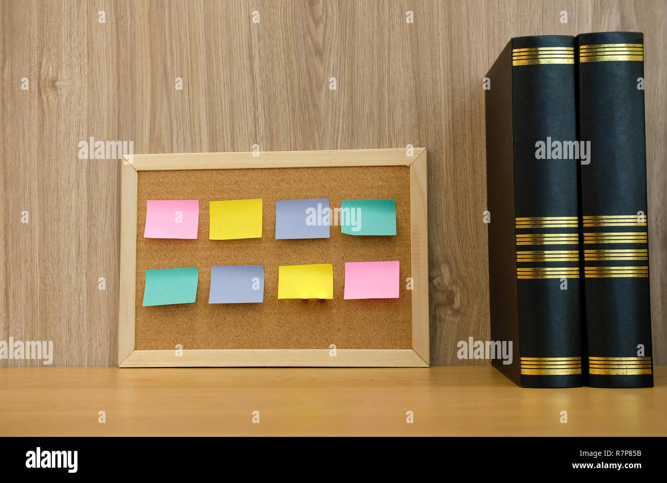 sticky notes paper reminder on cork board & book at workplace ...