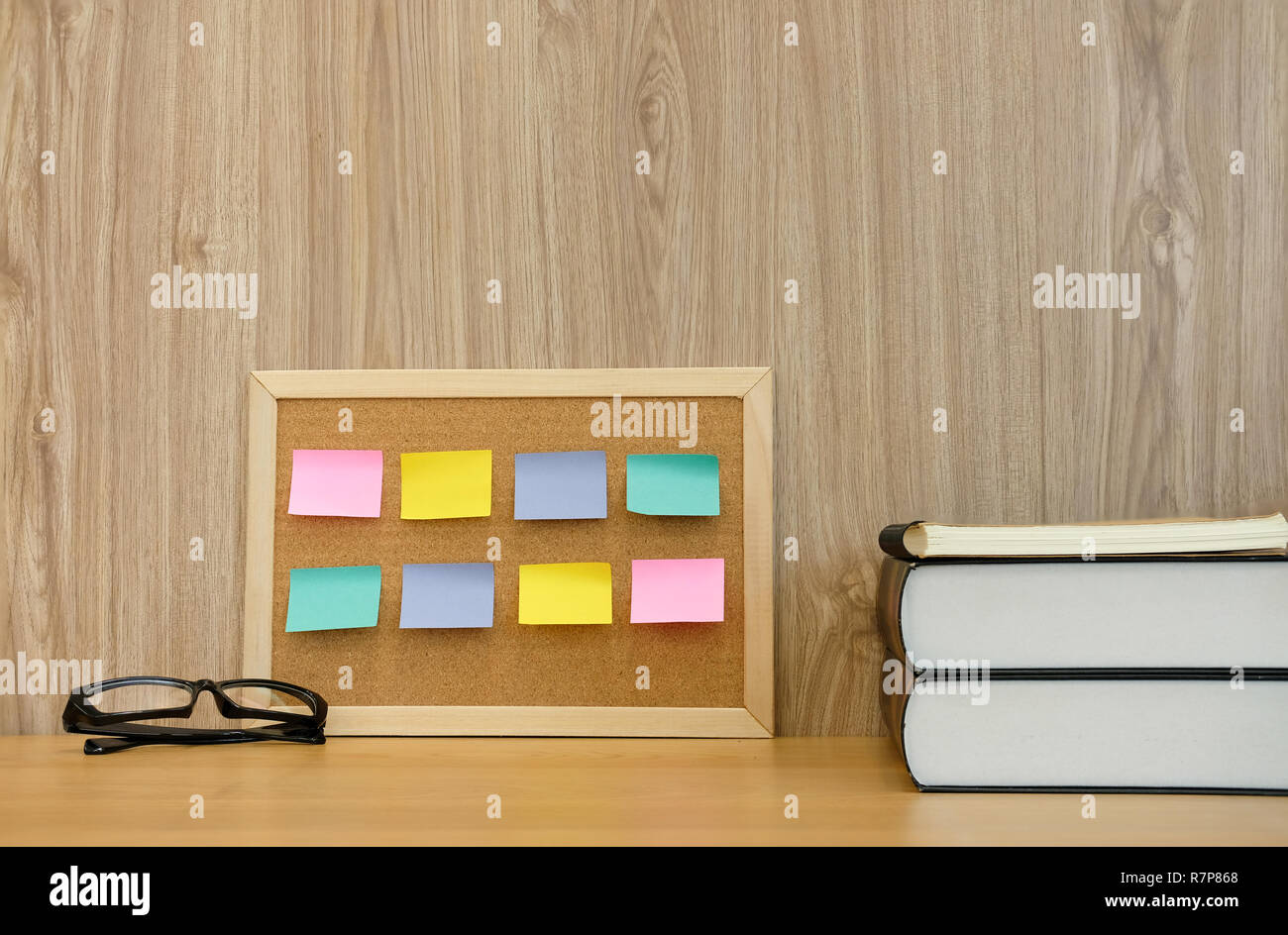 sticky notes paper reminder on cork board & book at workplace ...