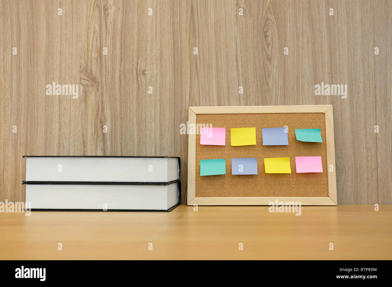 sticky notes paper reminder on cork board & book at workplace ...