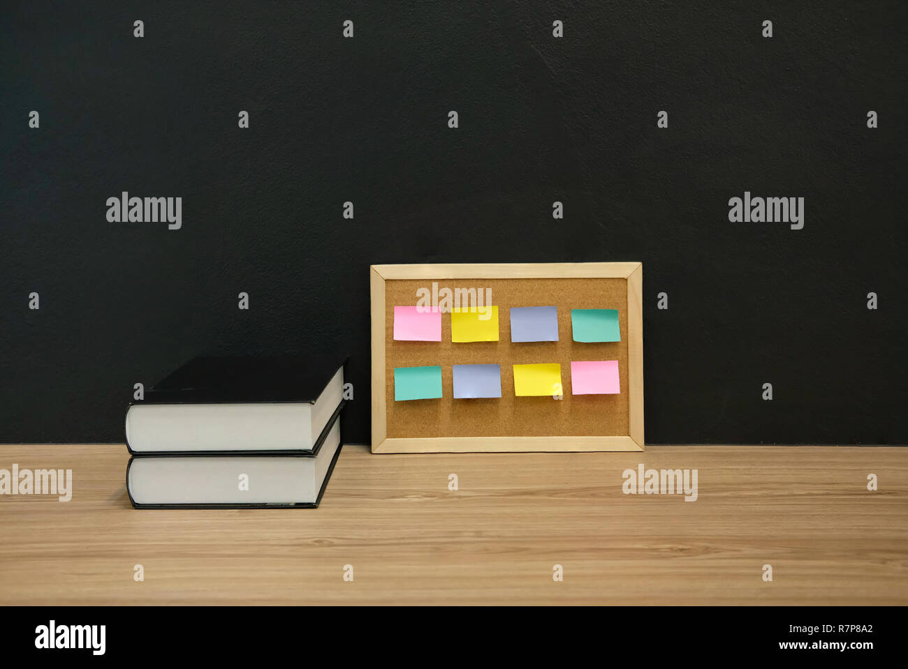 sticky notes paper reminder on cork board & book at workplace ...