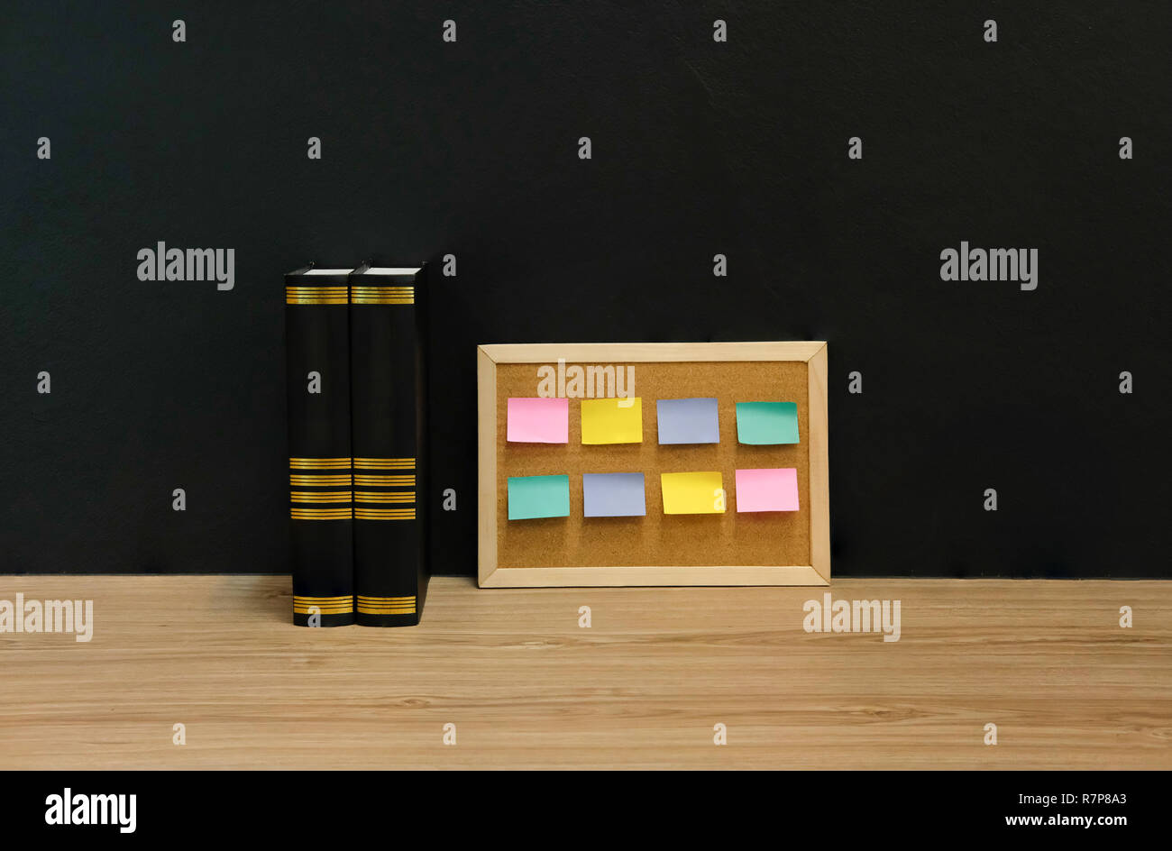 sticky notes paper reminder on cork board & book at workplace ...