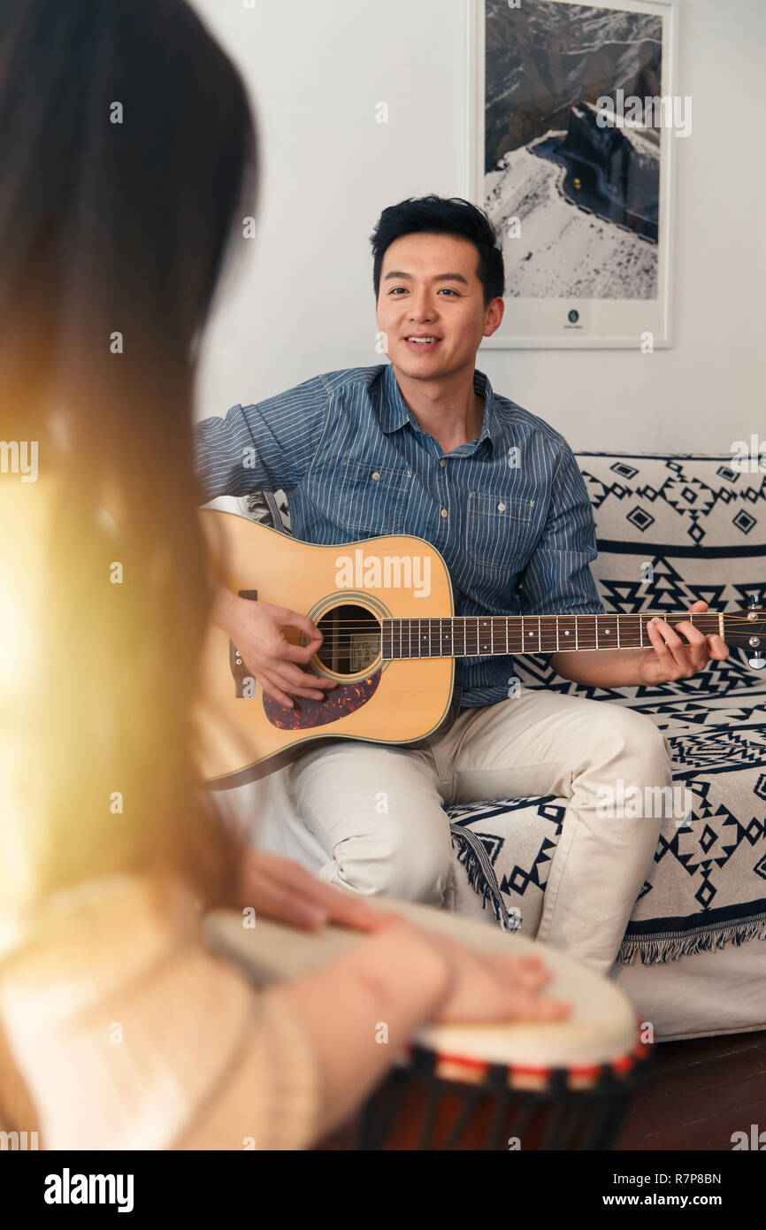 Happy couples playing Musical Instruments at home Stock Photo - Alamy