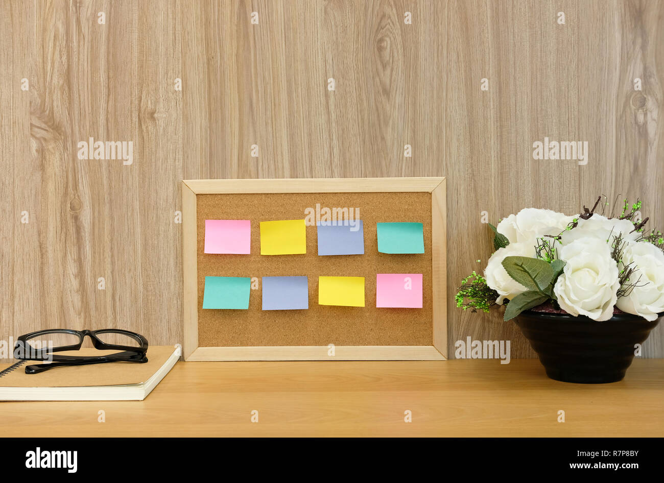 sticky notes paper reminder on cork board & notebook at workplace ...