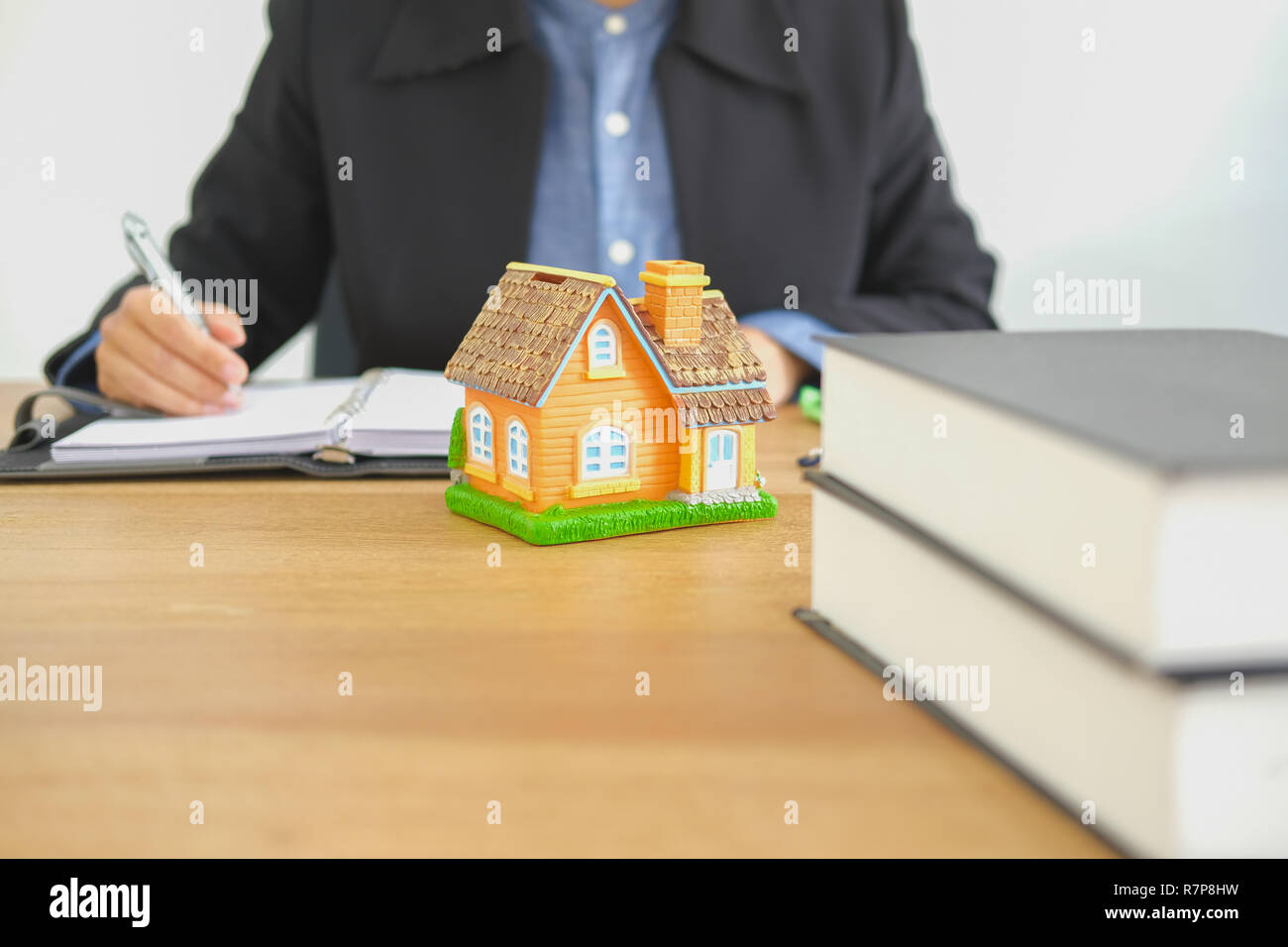 real estate agent realtor writing note with house model. buying selling ...