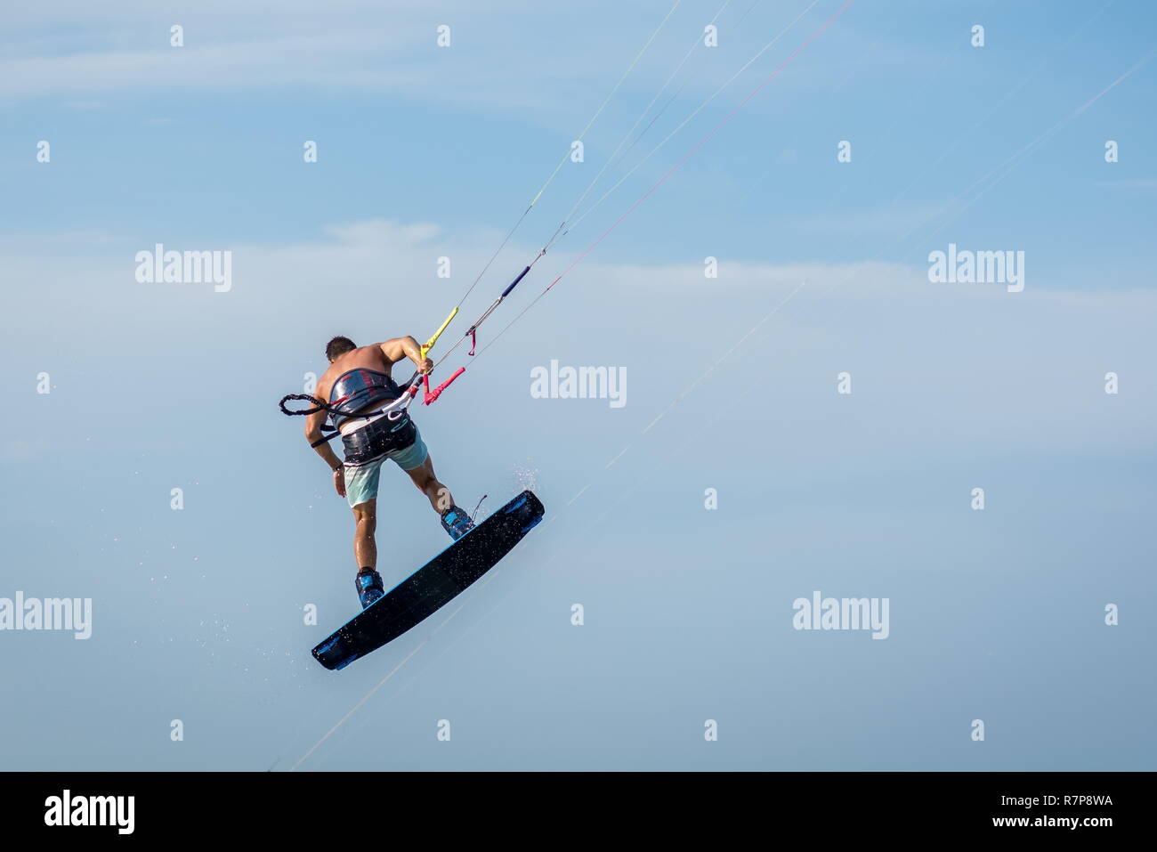 kitesurfer kiteboarder male athlete doing kite tricks and jumps while ...