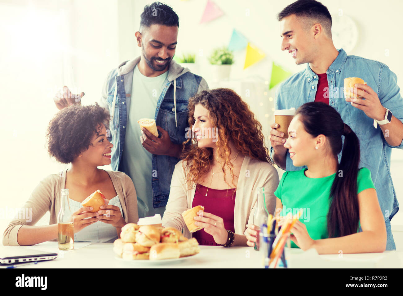 happy friends or team eating at office party Stock Photo - Alamy