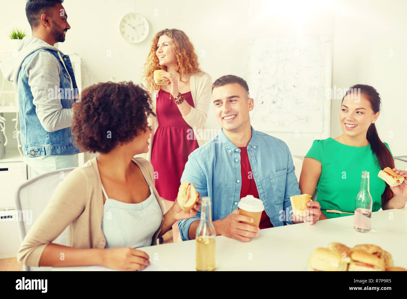 happy friends or team eating at office Stock Photo - Alamy