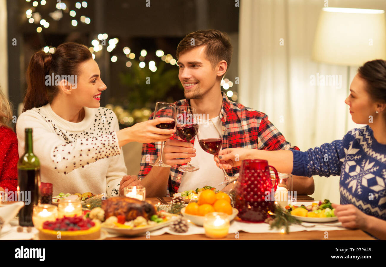 happy friends drinking red wine at christmas party Stock Photo - Alamy