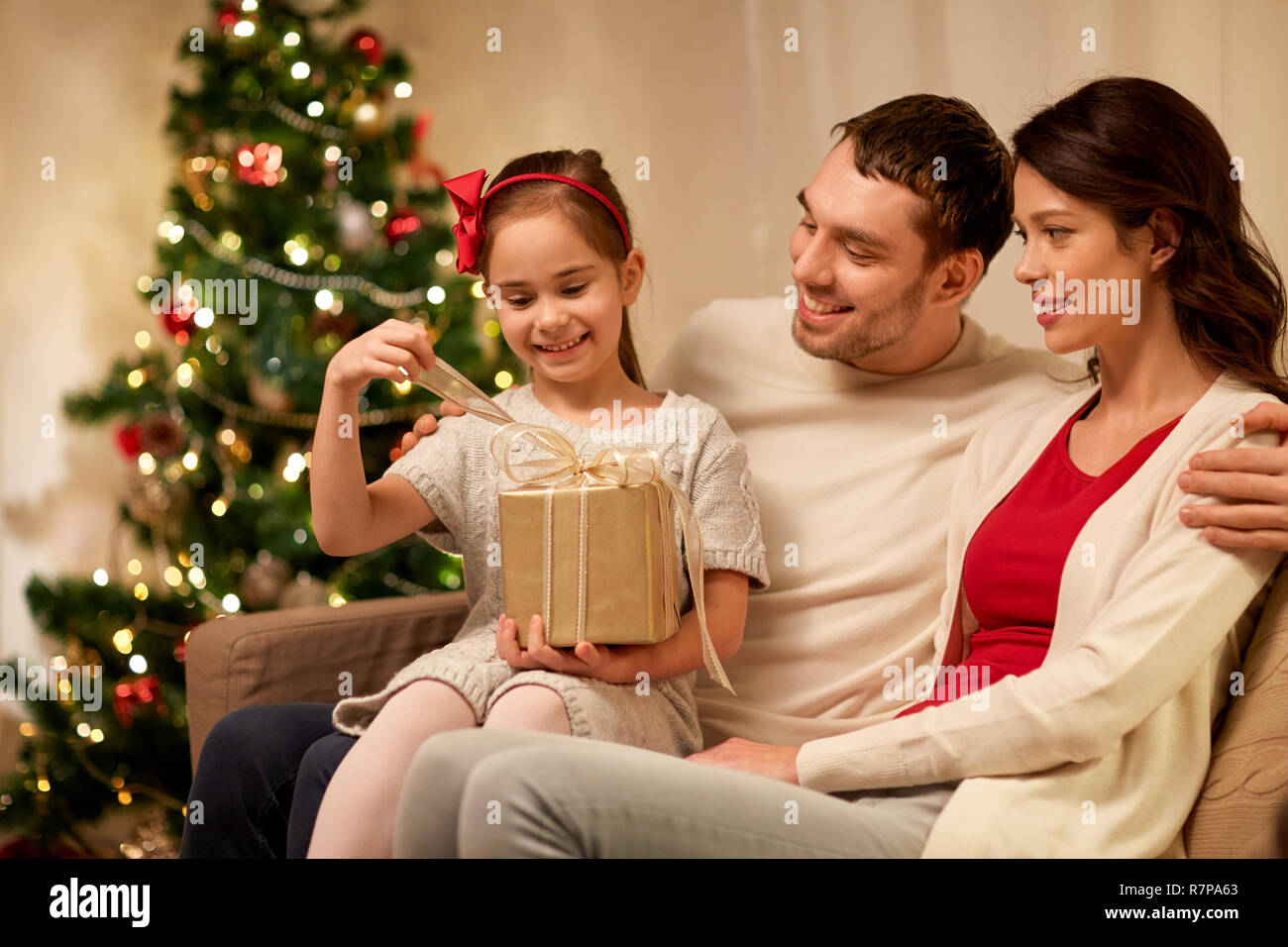 happy family with christmas present at home Stock Photo - Alamy