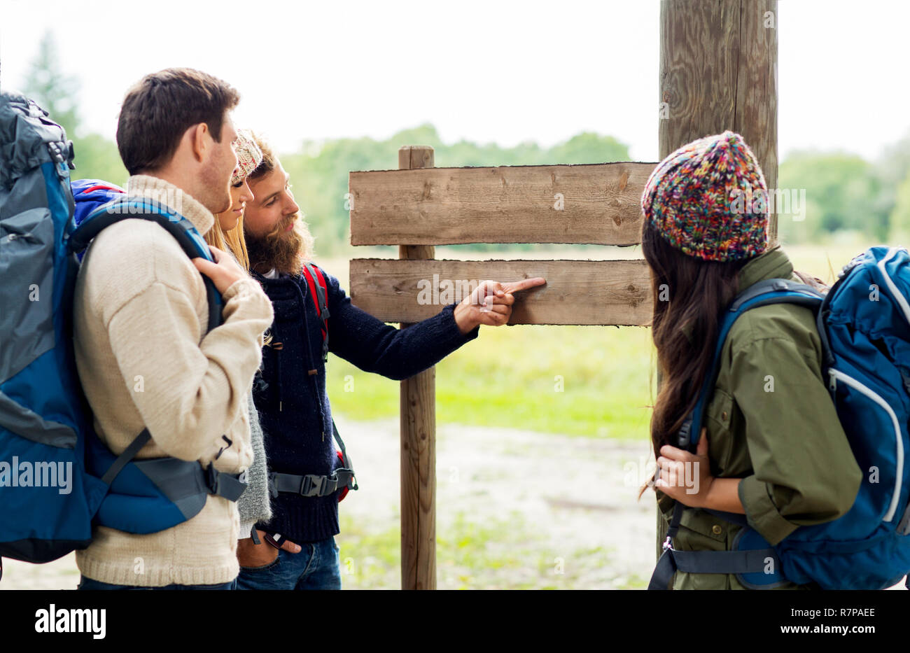 hiking friends with backpacks at signpost Stock Photo - Alamy