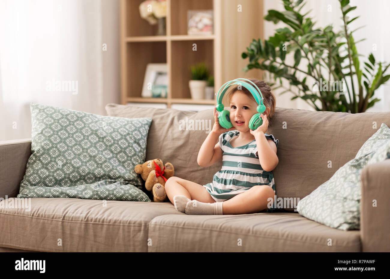 redhead baby girl in headphones listening to music Stock Photo - Alamy