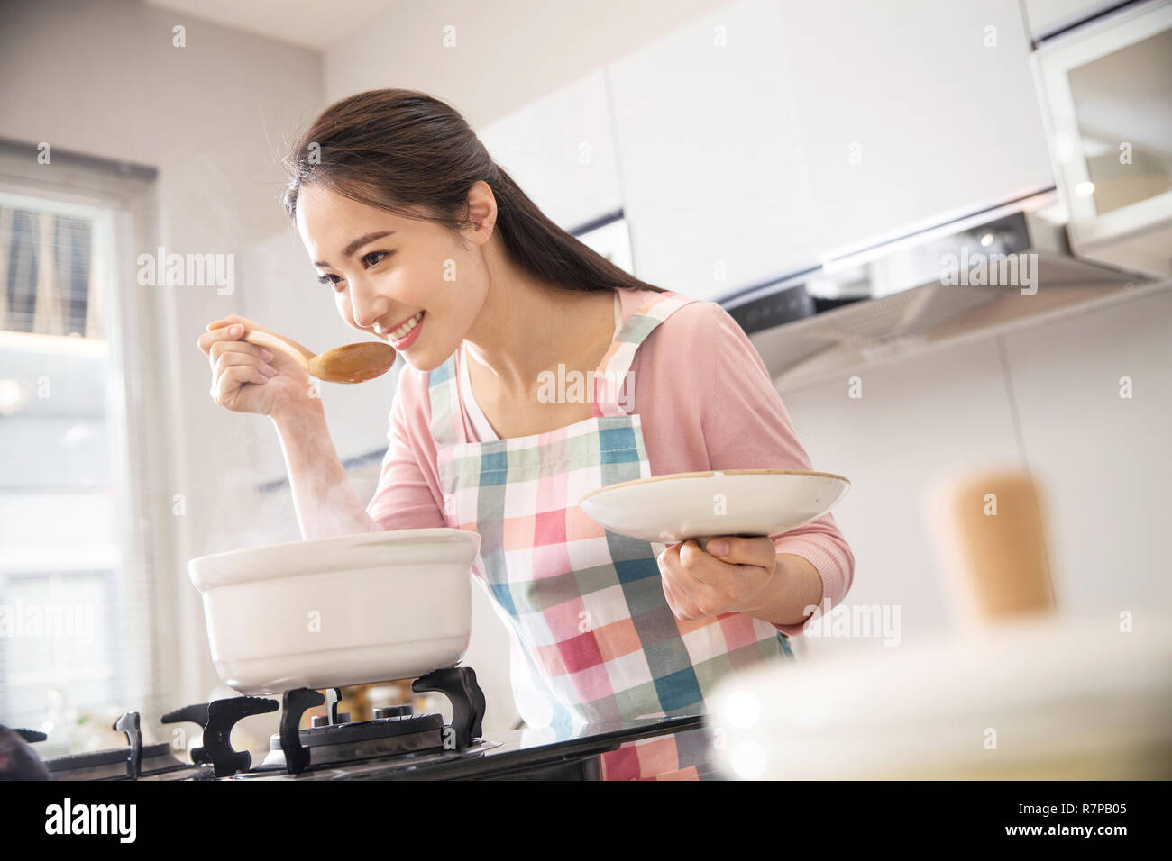 Young woman soup in the kitchen Stock Photo - Alamy