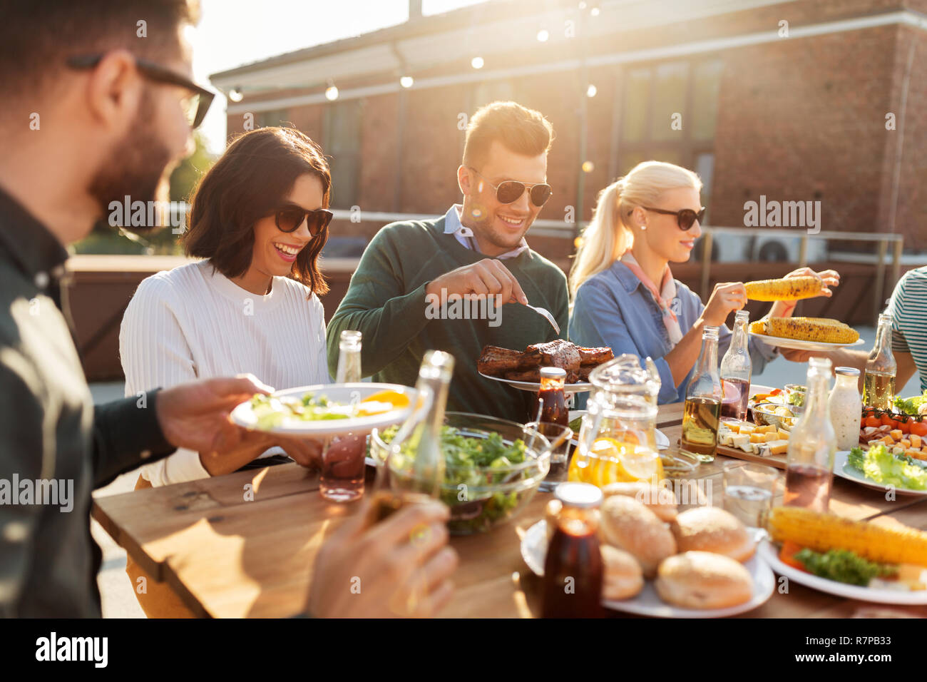 happy friends eating at barbecue party on rooftop Stock Photo - Alamy